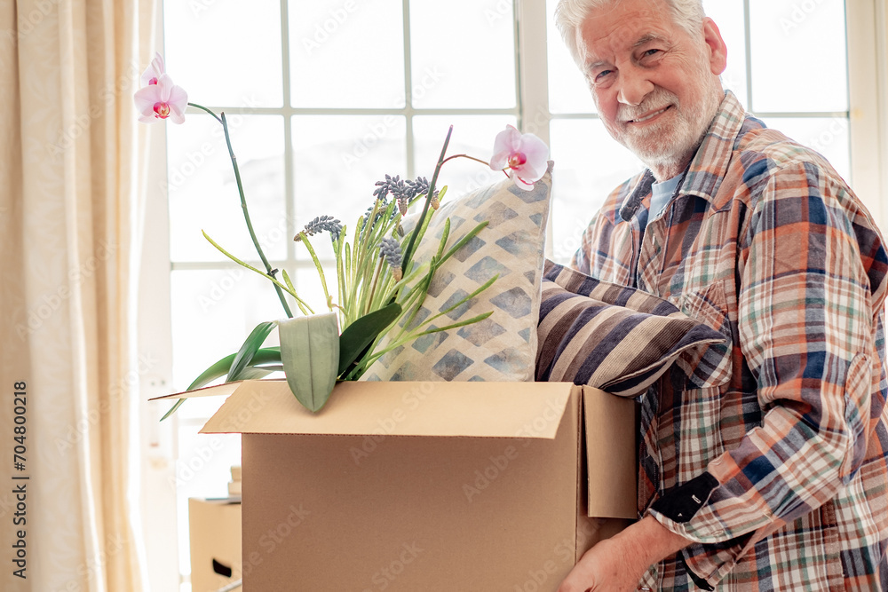 Handsome senior man involved in moving house moving cardboard boxes ...