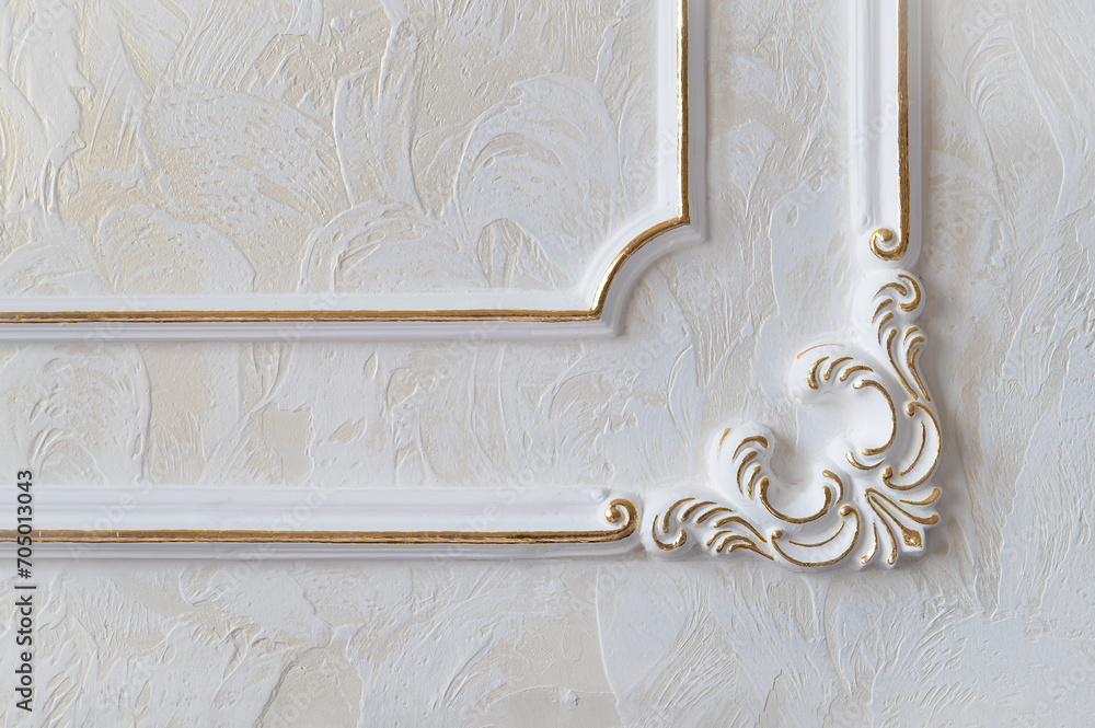 Plaster molding on the wall in the shape of a frame with gold paint ...