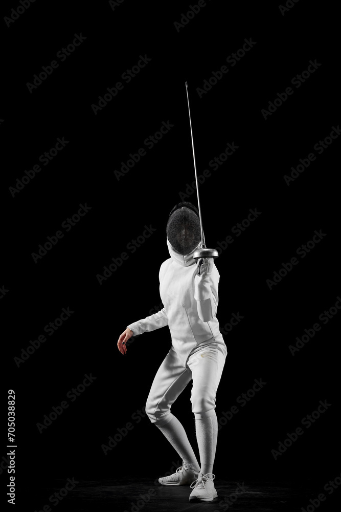 Swordswoman, professional female fencer's poised stance, against black ...
