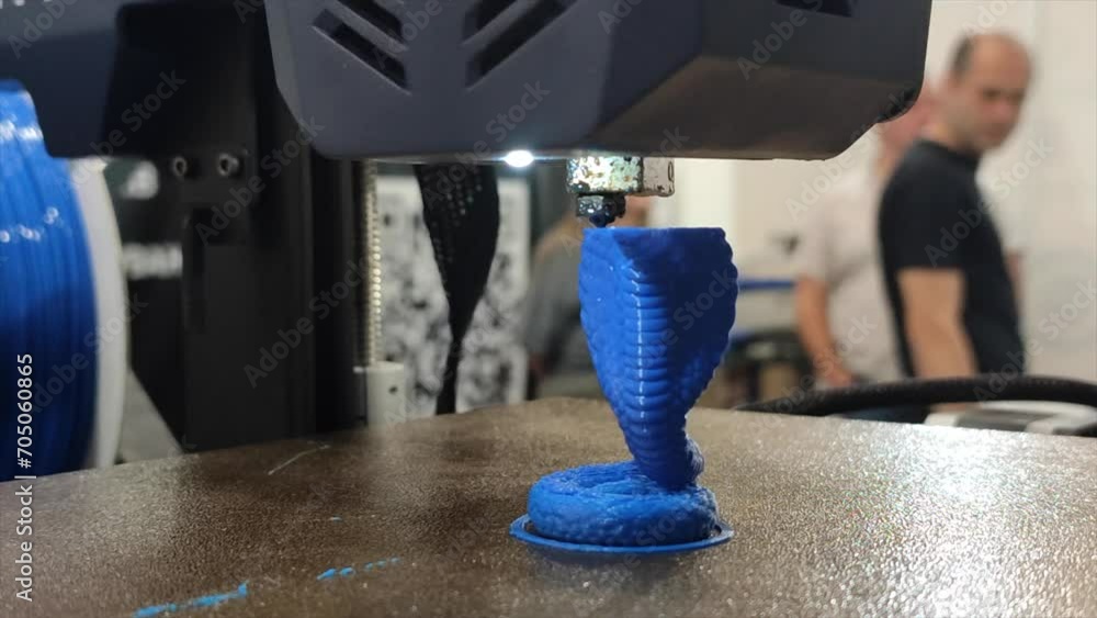 3D printer working close-up. 3D printer prints a model from molten blue ...