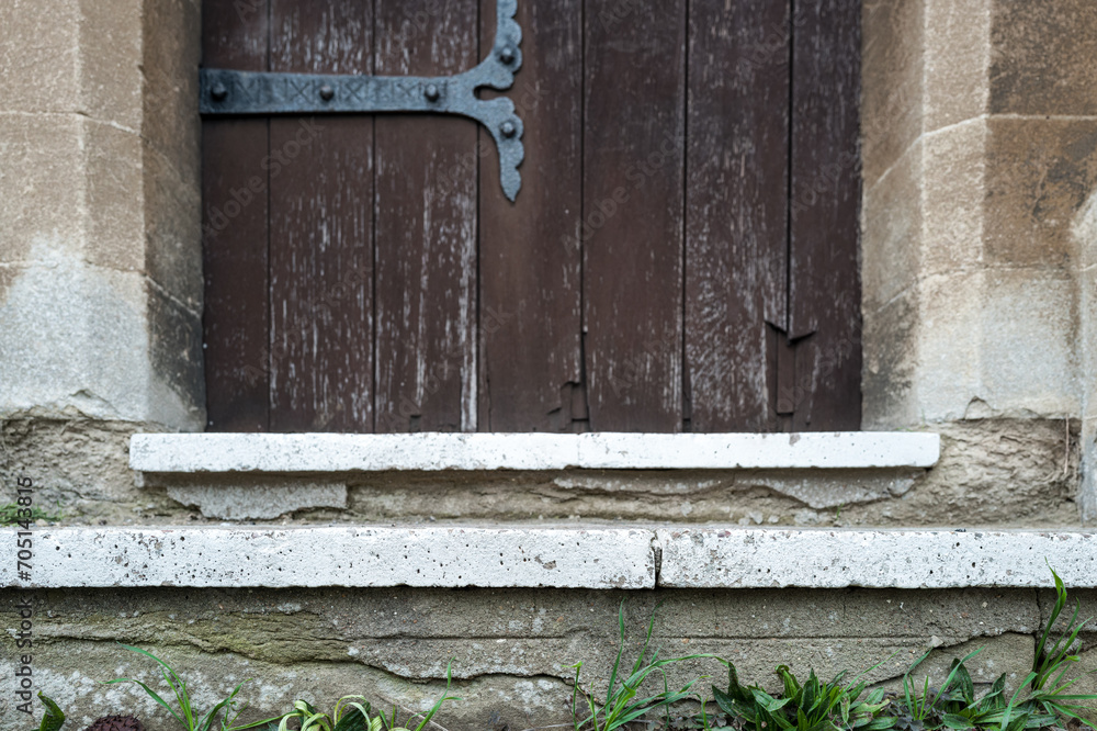 Shallow focus of a painted white stone doorstop leading to a very old ...