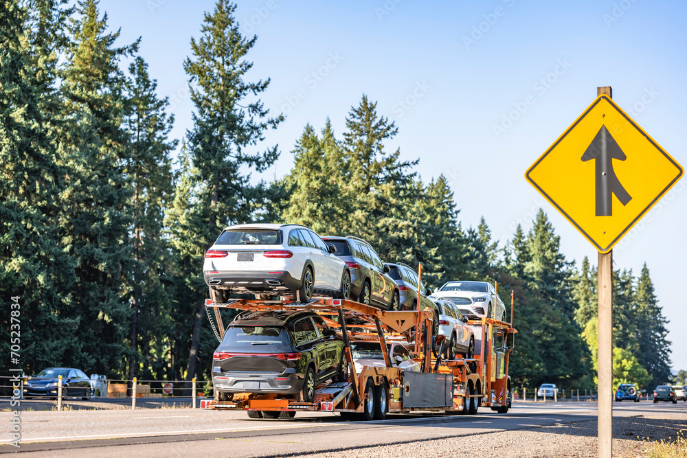 Loaded classic car hauler big rig orange semi truck transporting cars ...