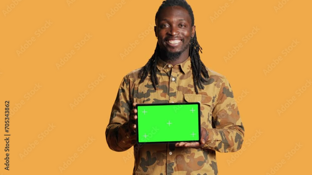 Male model holding laptop with greenscreen layout in studio, posing ...