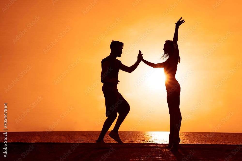 latin hispanic couple is dancing bachata salsa tango on summer beach. Sunset sky. Two hot ...