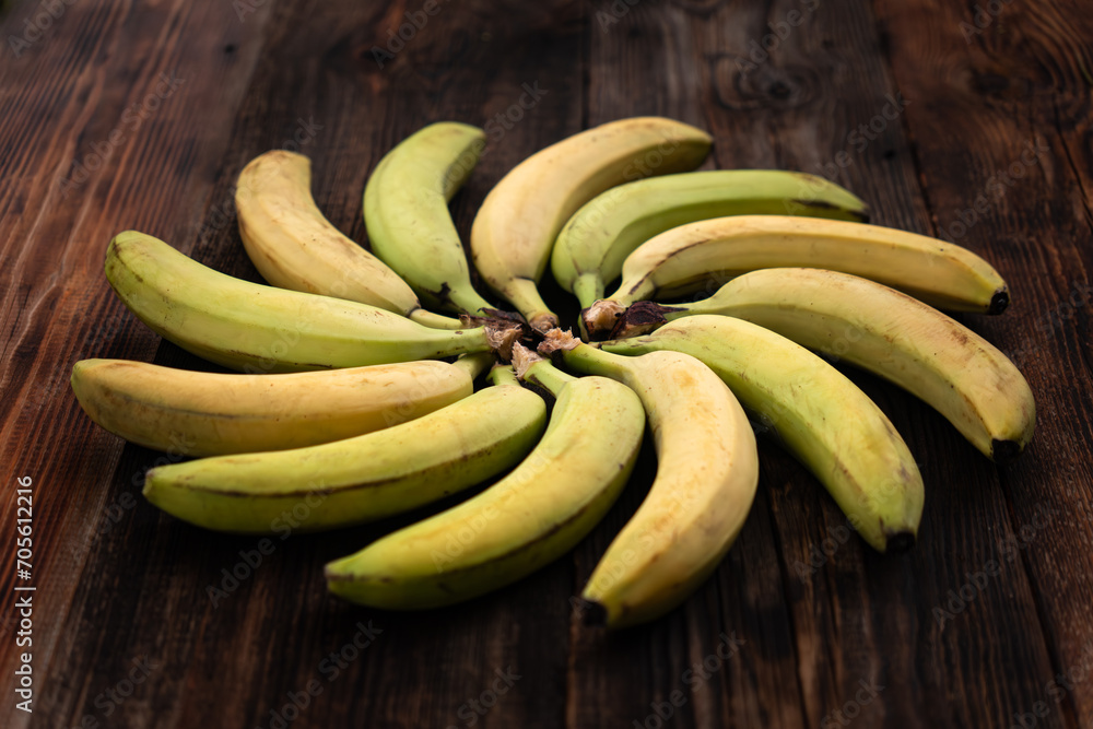 Bananas on a brown wooden table top view. Figured position of bananas ...