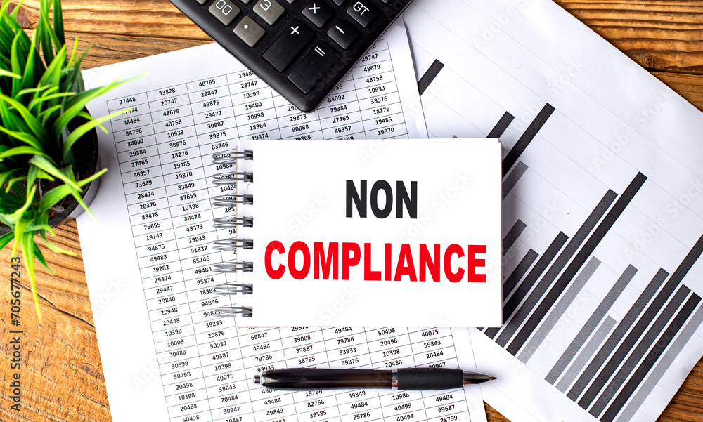 NON COMPLIANCE text on a notebook with chart and calculator Stock Photo ...