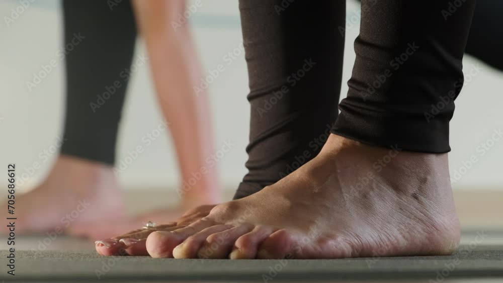 Woman places hand on floor beside foot while performing exercise ...