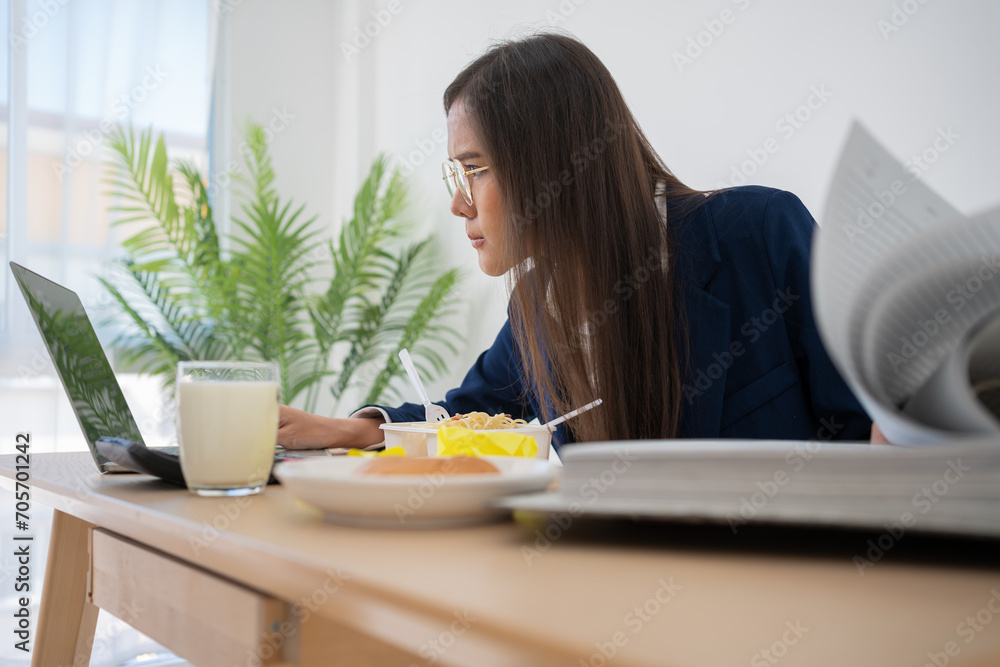 Busy and tired businesswoman eating spaghetti for lunch at the Desk ...