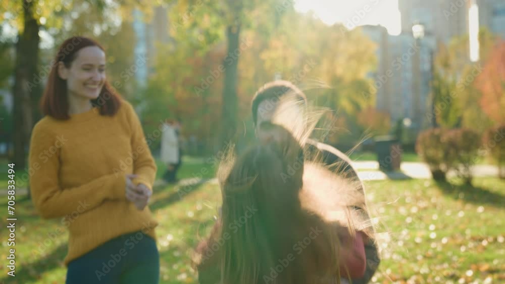 Caucasian carefree family in autumn sunny park parents daughter running ...