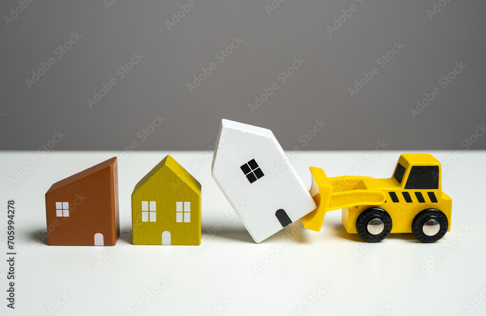 A bulldozer demolishes houses. Demolition of illegal and unsafe ...