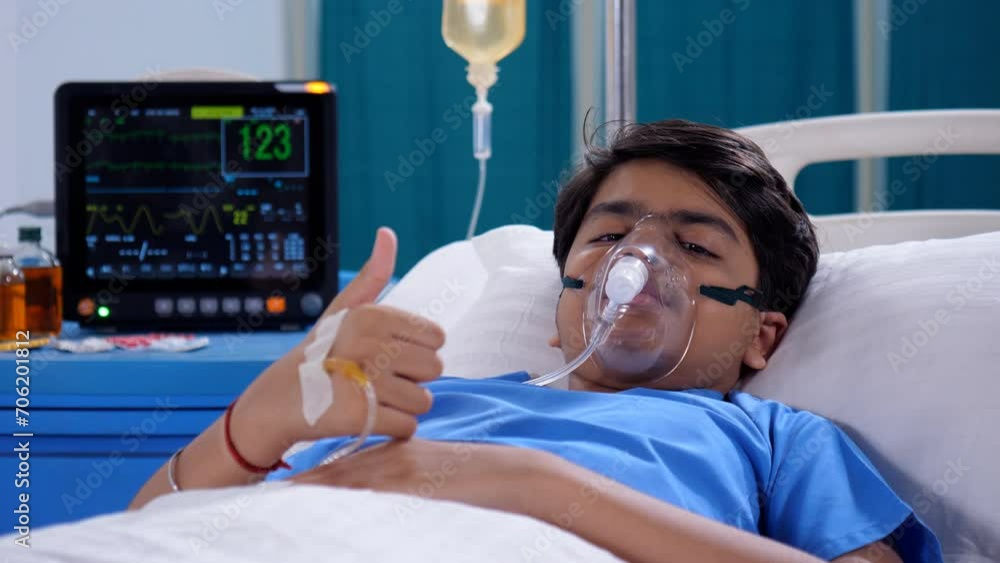 A sick Indian boy is doing a thumbs-up gesture while relaxing in the ...