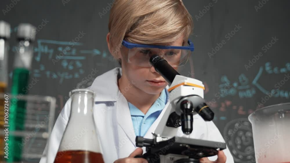 Smart boy using microscope analysis sample at science laboratory in STEM science class or ...