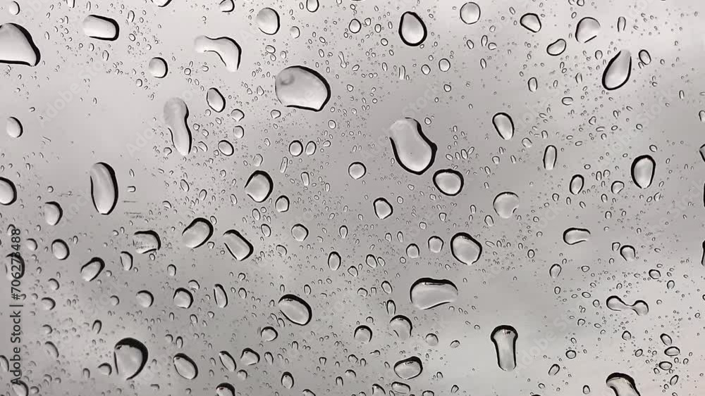 Rainwater wets the clear glass surface. Raindrops flow down. Footage of ...