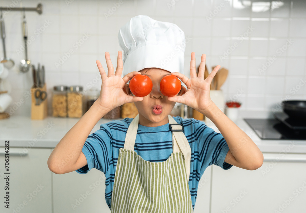 Asian Little chef boy cooking breakfast in the kitchen. Funny kids are ...