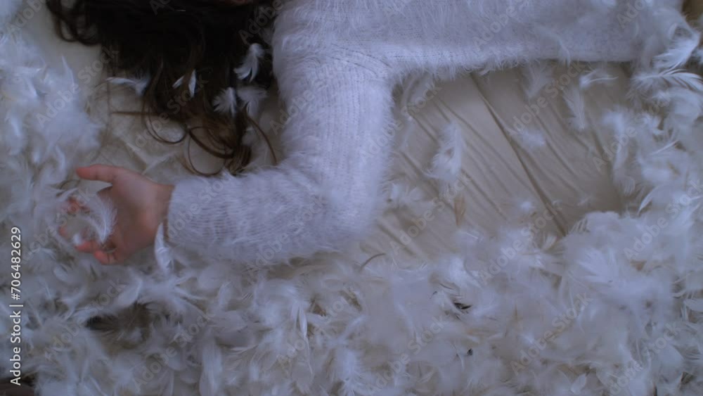 Happy Little Girl Falling on bed with thousands of feathers flying in ...