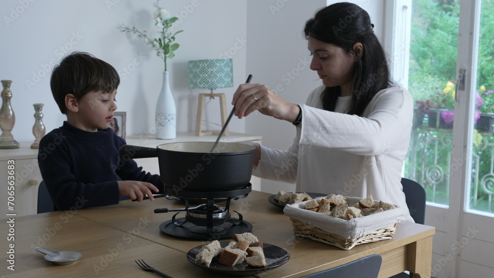 Fondue at home, Mother and child eating traditional Swiss food, bread ...