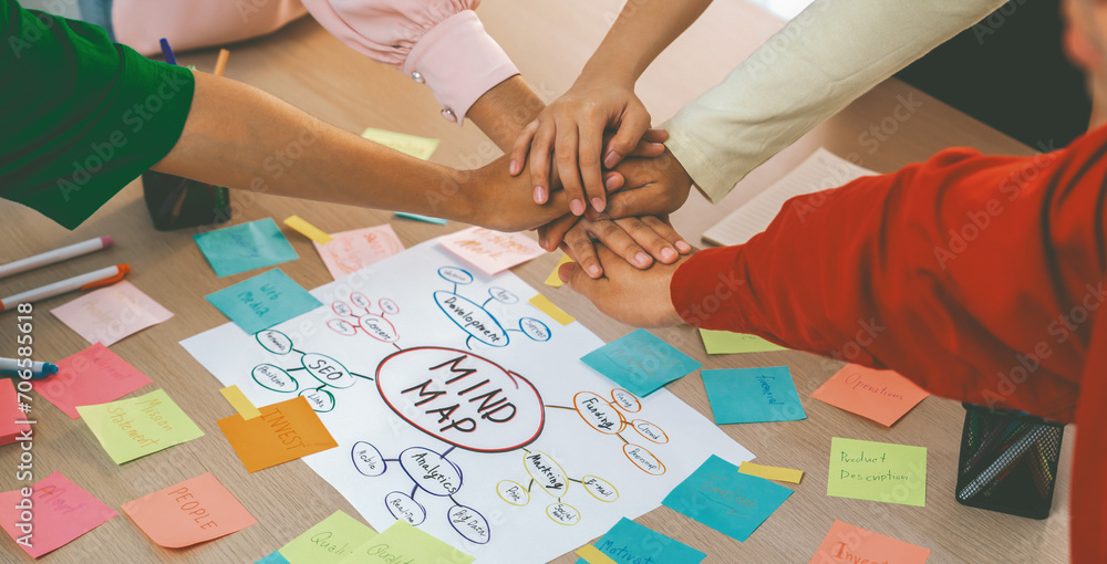 Foto de A group of business people putting their hands together at ...