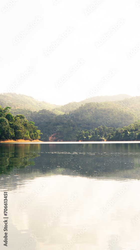Hermoso reflejo de montañas y arboles en el agua de una represa en ...