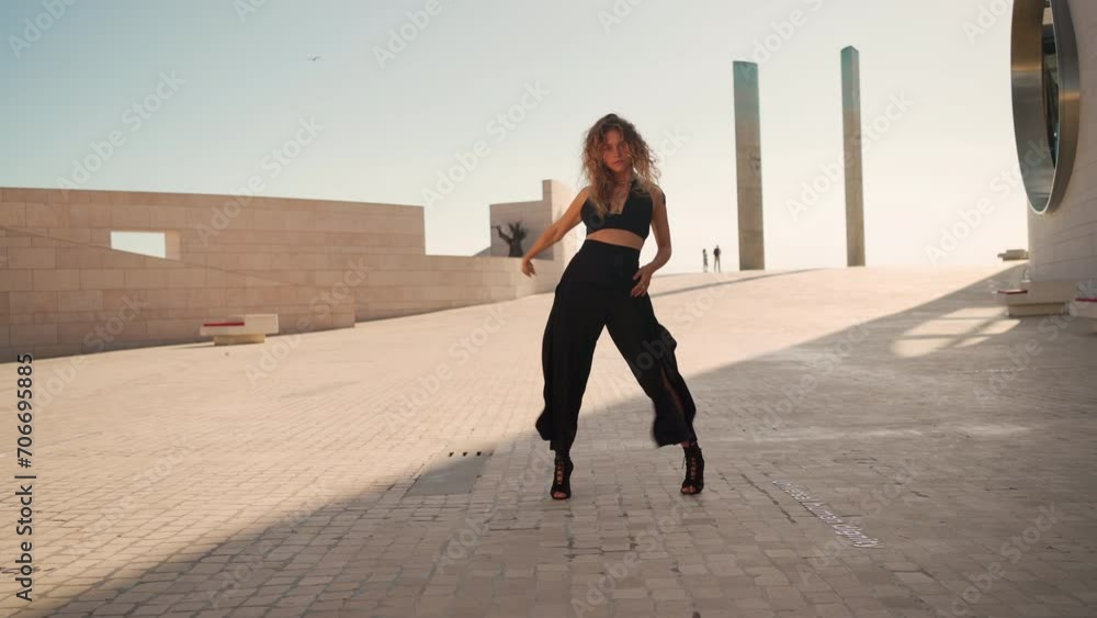 Full length shot of woman in black dress dancing gracefully in wind ...