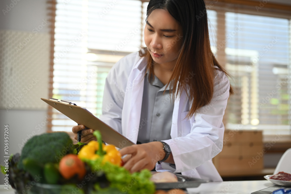 Female dietitian in medical uniform working in her office. with ...