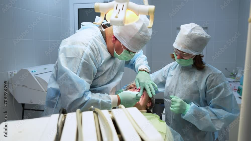 Vidéo Stock Male dental surgeon, nurse doing medical operation on root ...