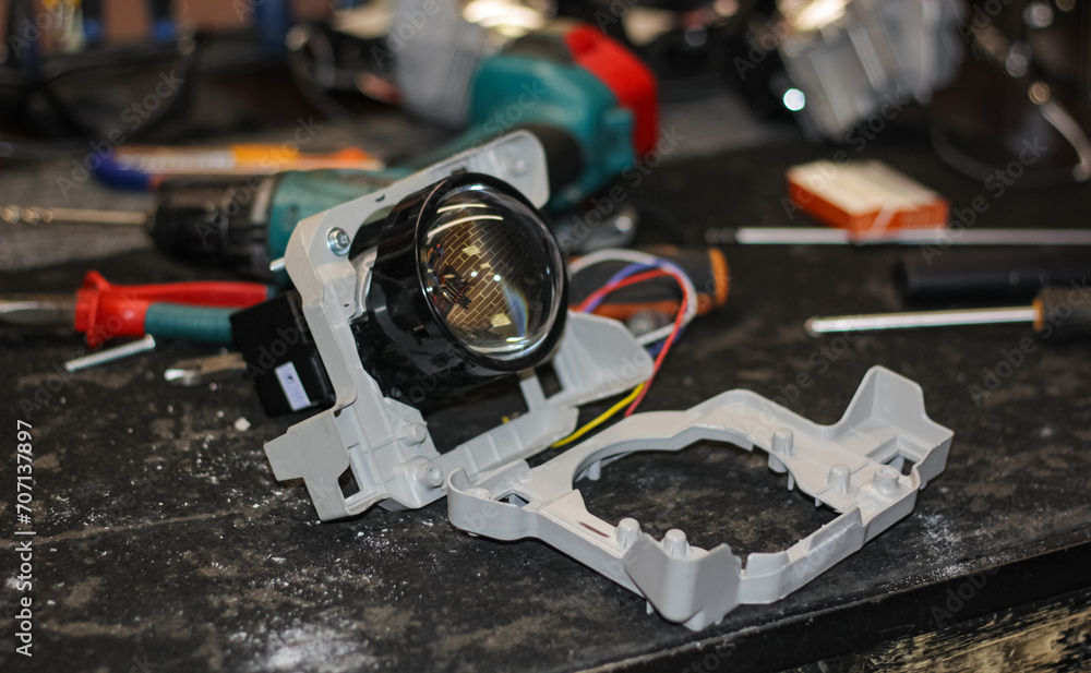 The car mechanic installs the lens in the headlight housing. The ...