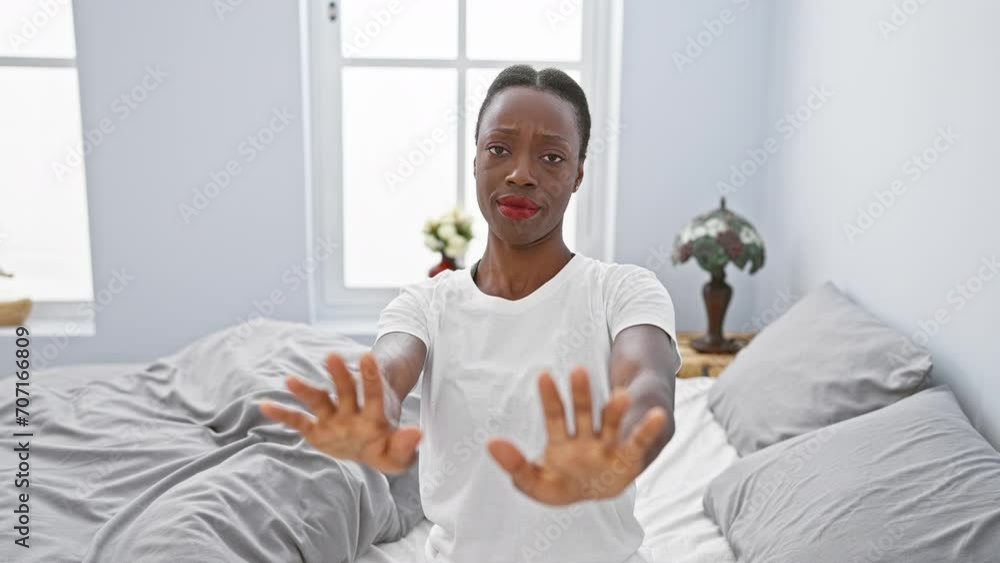 African american woman in her bedroom, lying on her bed showing a clear ...
