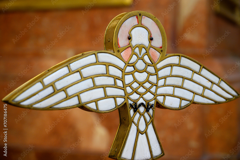 A dove, the symbol of the Holy Spirit, on the cover of a baptismal font ...