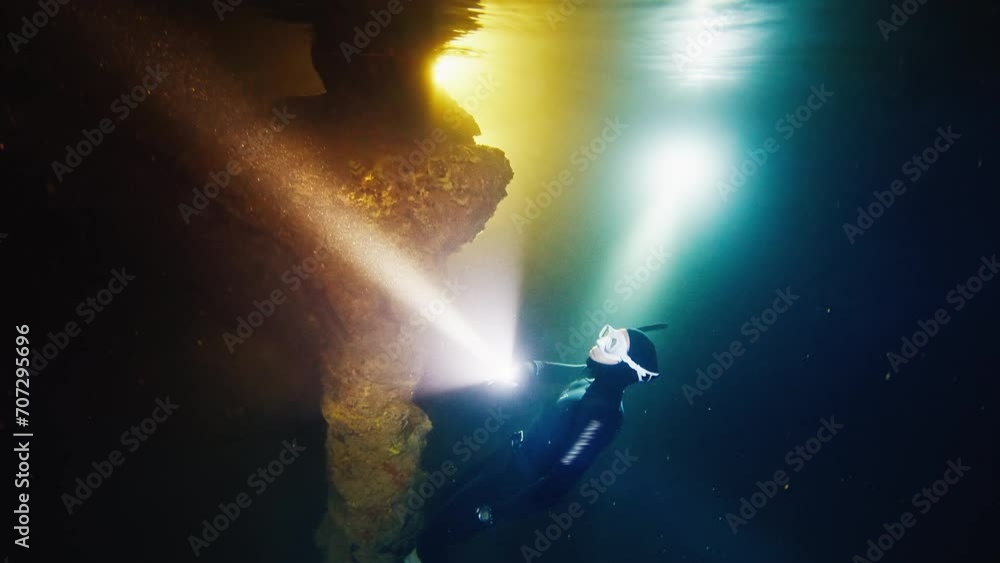 Cave freediving. Freediver swims underwater and explores intricate ...
