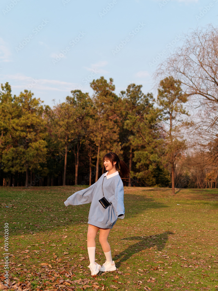 Beautiful young Chinese woman dancing with joy in sunny summer forest ...
