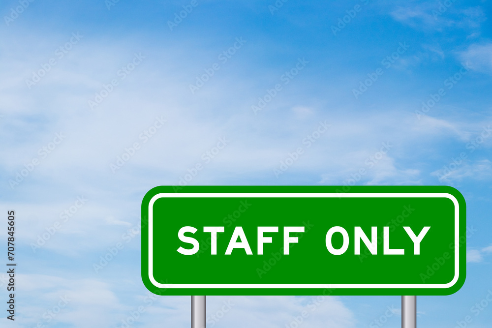 Green color transportation sign with word staff only on blue sky with ...