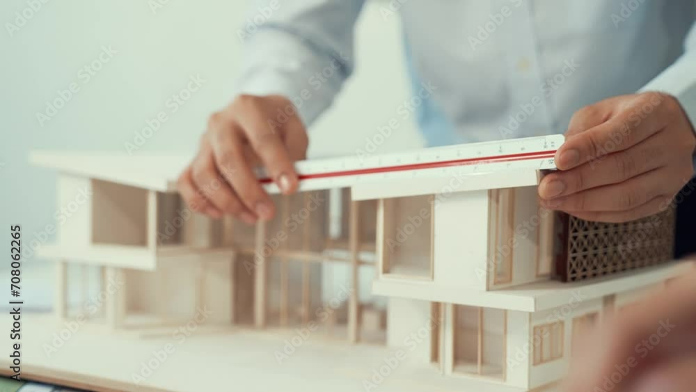 Professional male architect using ruler to measure house model length ...