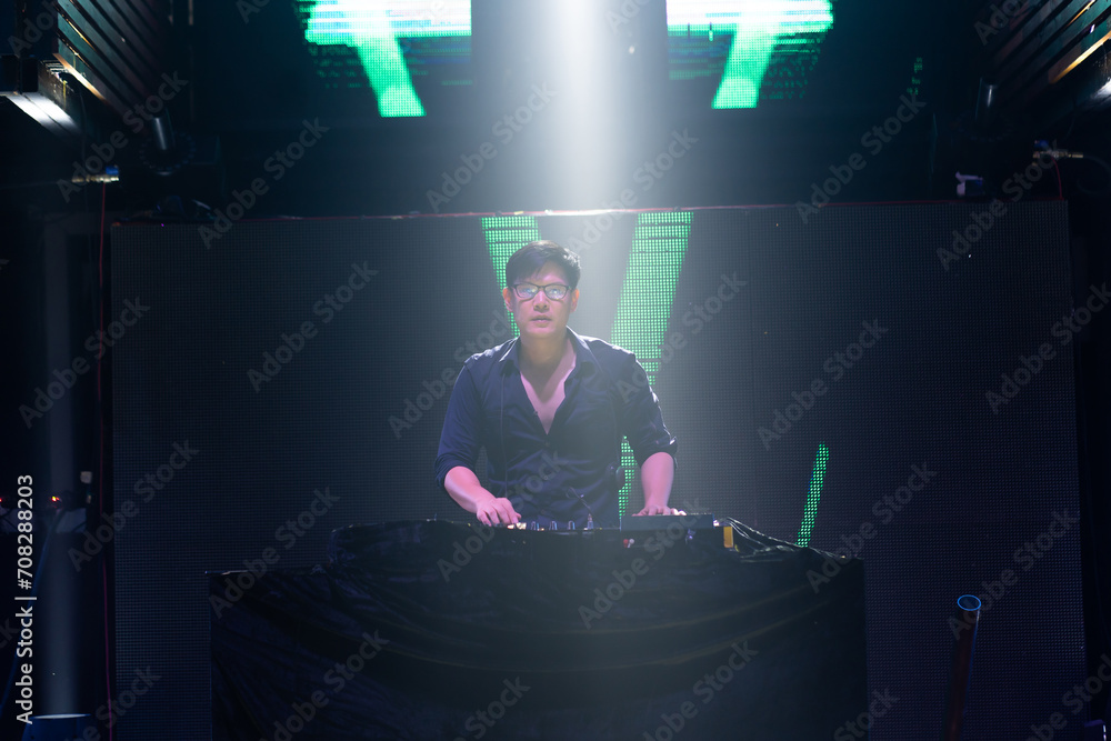 DJ with Turntables at nightclub. Group of diverse young people dancing ...