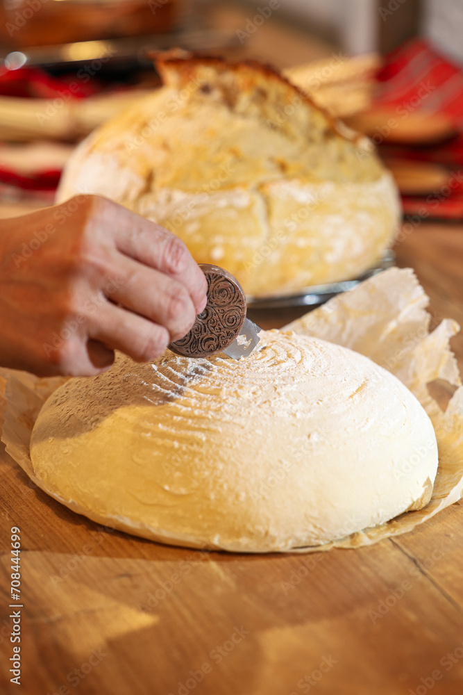 Bread scoring. Close up photo with a male hand scoring the sourdough ...