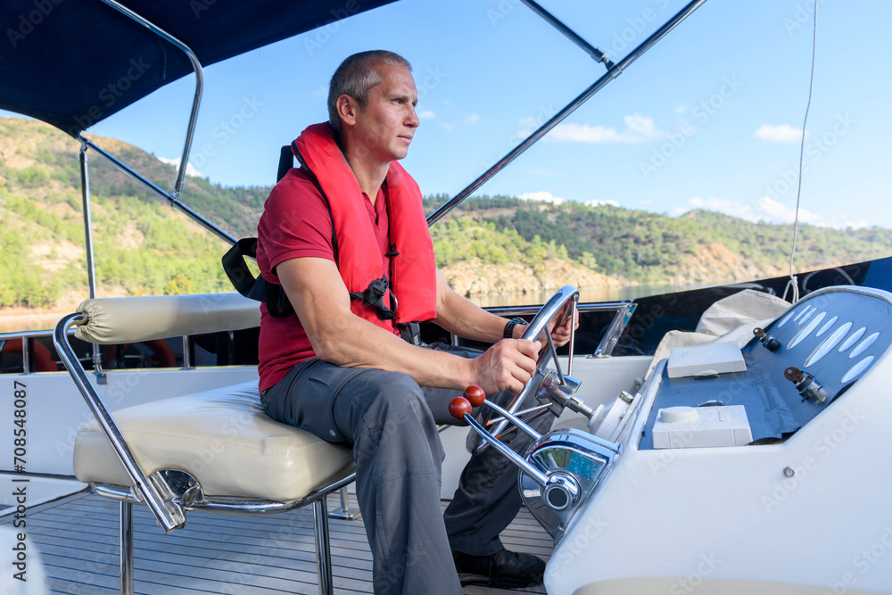 Young caucasian man steering motor yacht. Motor boat captain. Master of ...