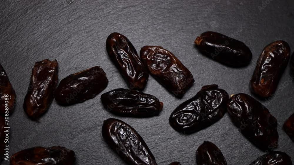 sweet, dried dates on a black stone slab. Healthy food from the east ...