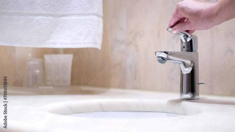 Close-up slow motion of caucasian female hand opening a mixer tap in a ...