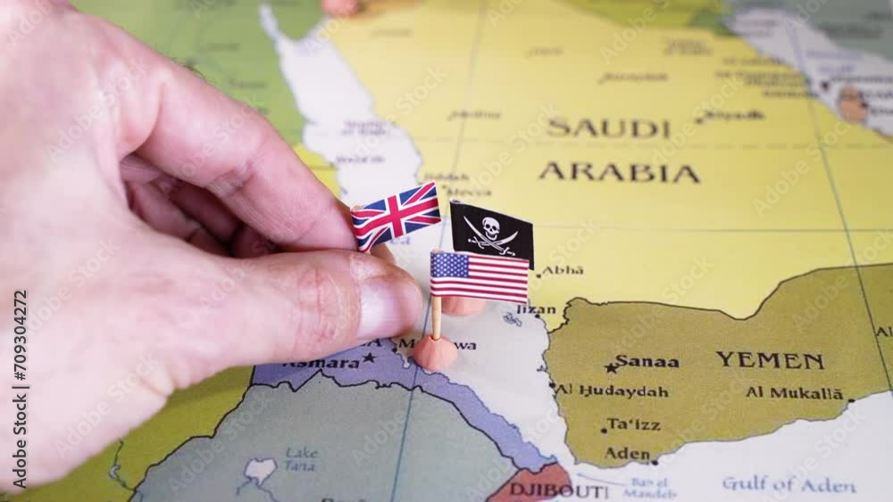 Hand placing pins adorned with the flags of the USA, UK, European union ...