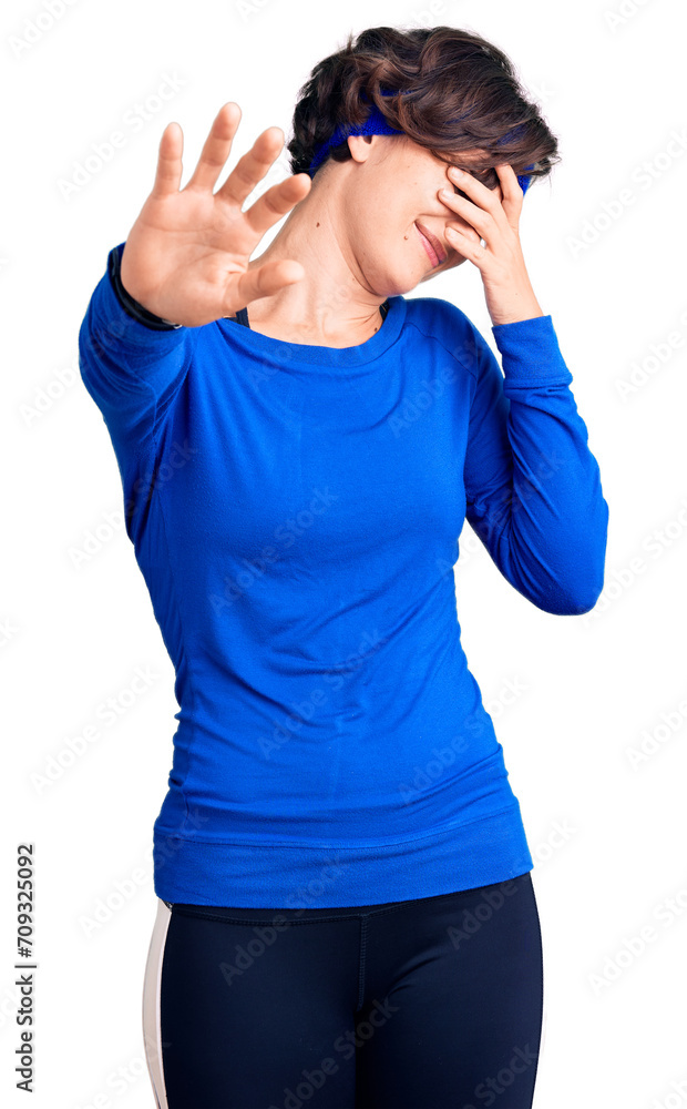 Beautiful young woman with short hair wearing training workout clothes ...