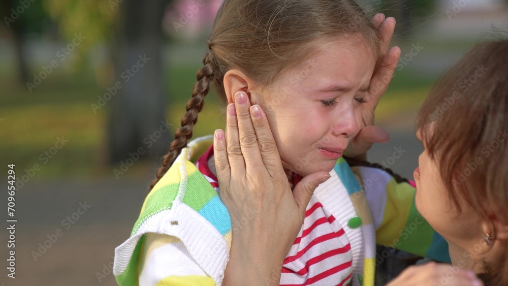 little child cries, tears child face, mother calms capricious kid girl ...