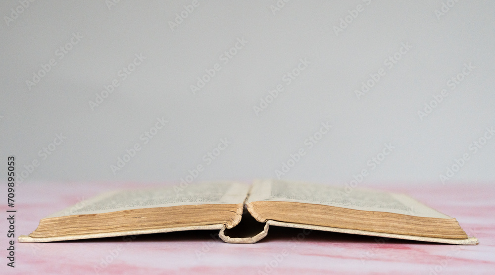 Livre ancien ouvert à plat devant un fond clair avec de l'espace vide ...