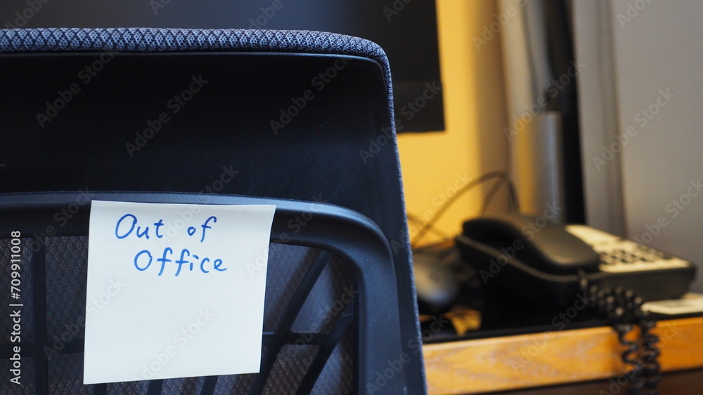yellow sticky note with handwritten words "Out of office!" on back of ...