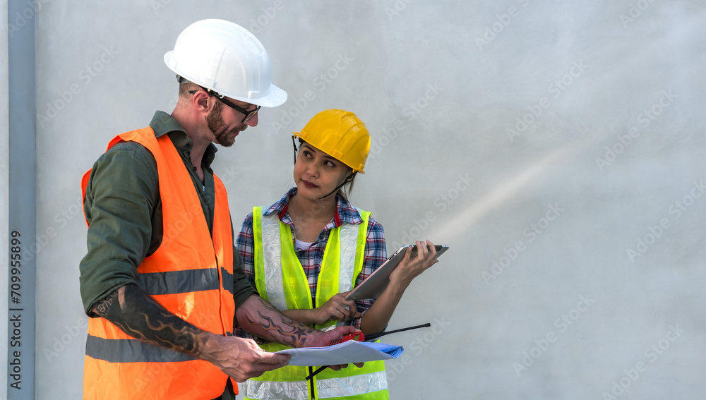 Young construction man and woman workers working together in ...