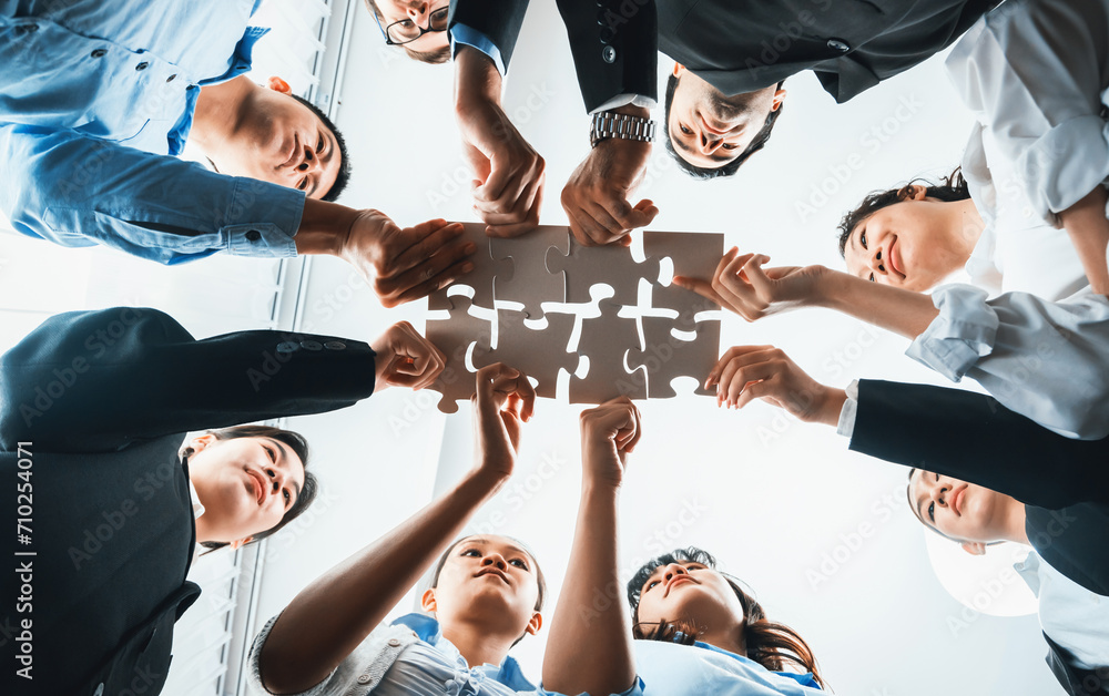 Multiethnic business people holding jigsaw pieces and merge them ...
