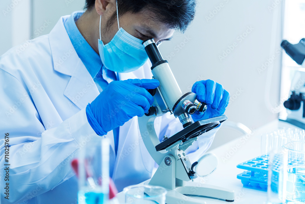 Scientist man look into Microscope research in science laboratory. Asian scientist look at ...