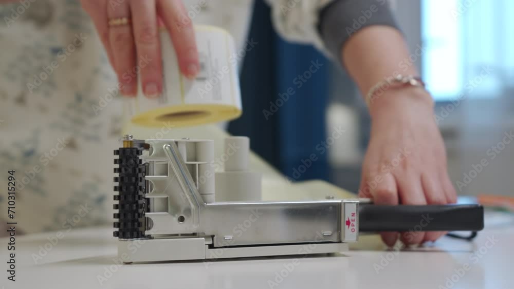 woman applying shipping barcode labels with handheld label applicator ...