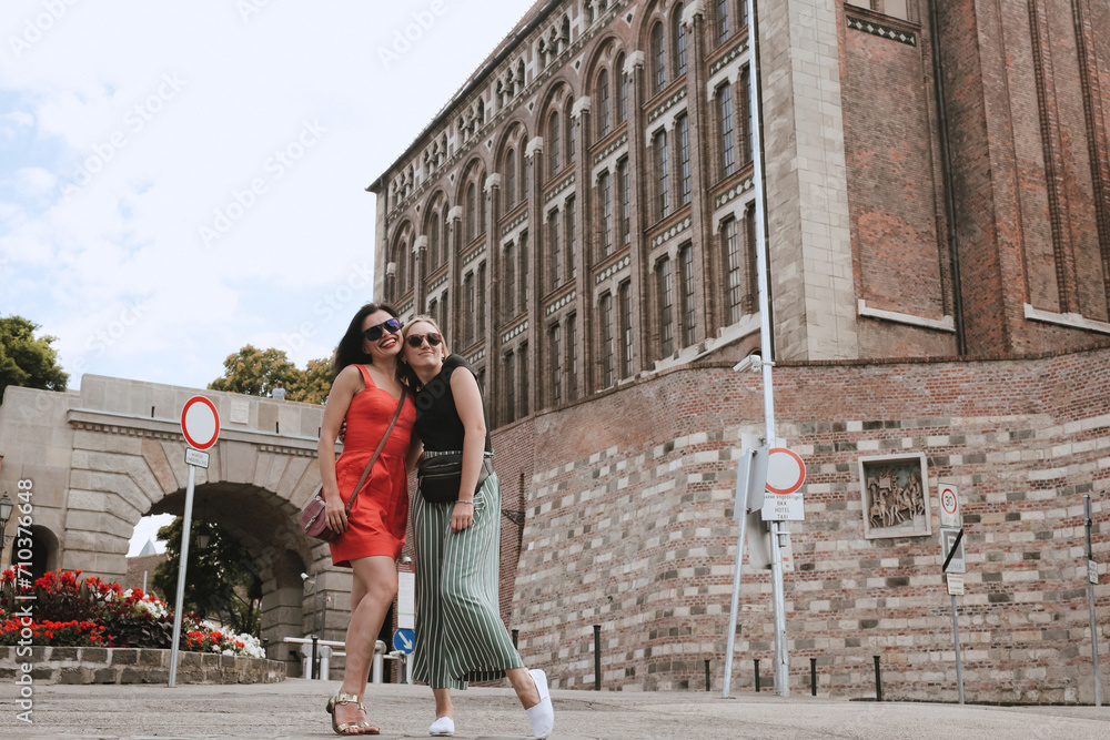 Women tourists walk through tourist places. Seeing the sights. Dressed ...