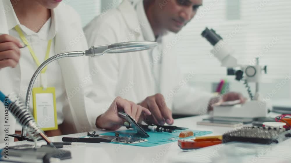Cropped shot of pair of service specialists repairing components of digital devices using ...