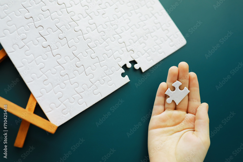 Intellectual puzzles. The puzzle is empty. The hand puts together ...