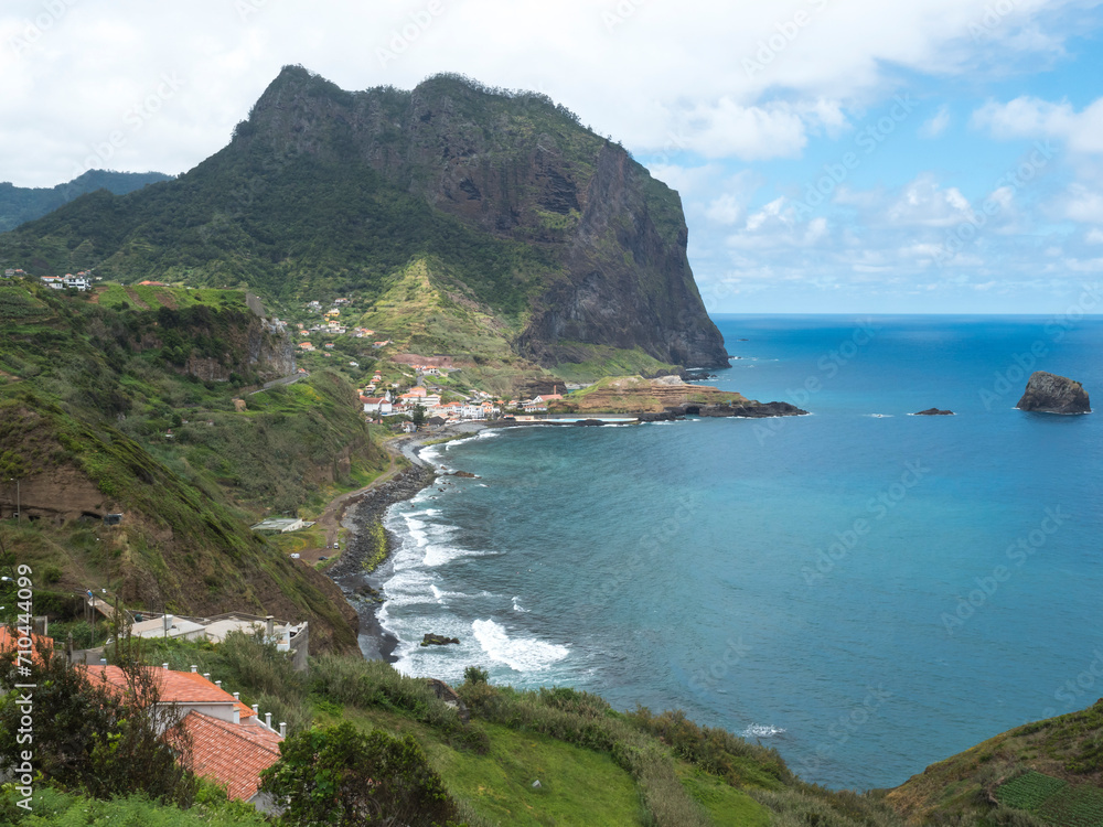 Aerial view of Porto da Cruz town with green cliff of Penha D'Aguia ...